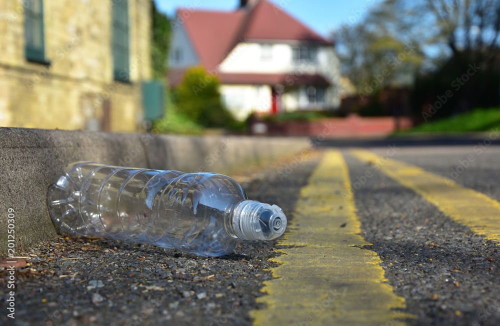 Discarded plastic bottle lying at the edge of an urban street Stock ...