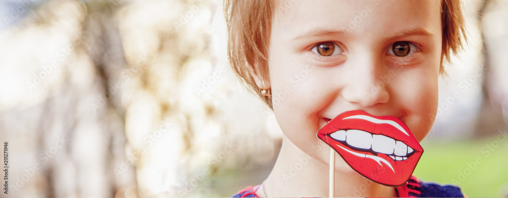 Funny beautiful little child girl playing with fake lips outdoors Stock ...