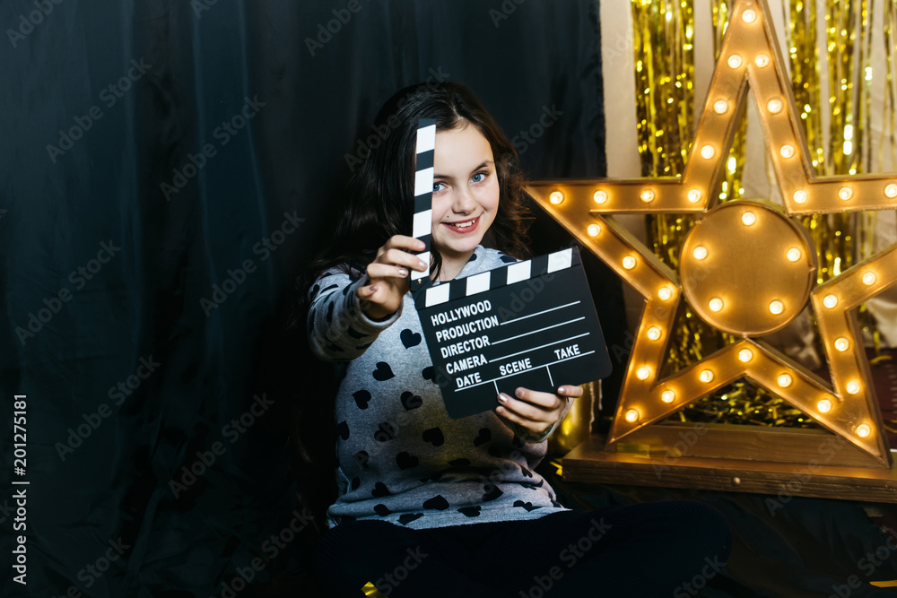 Happy child play with movie clapper or clapperboard. Little girl smile ...
