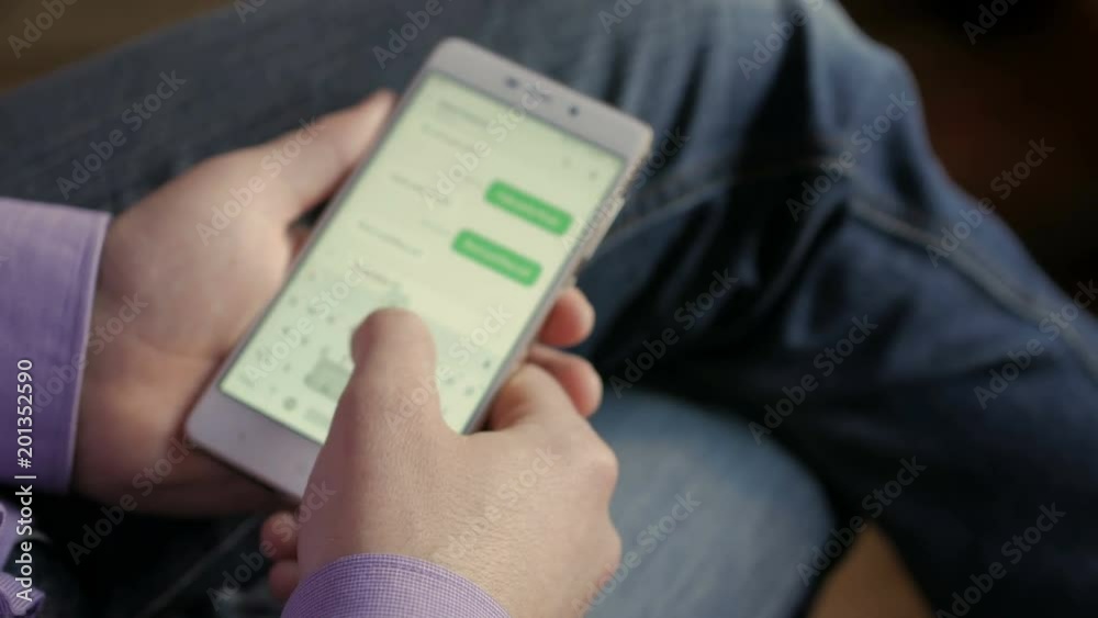 A man writes a texting SMS message using a smartphone. Male texting ...