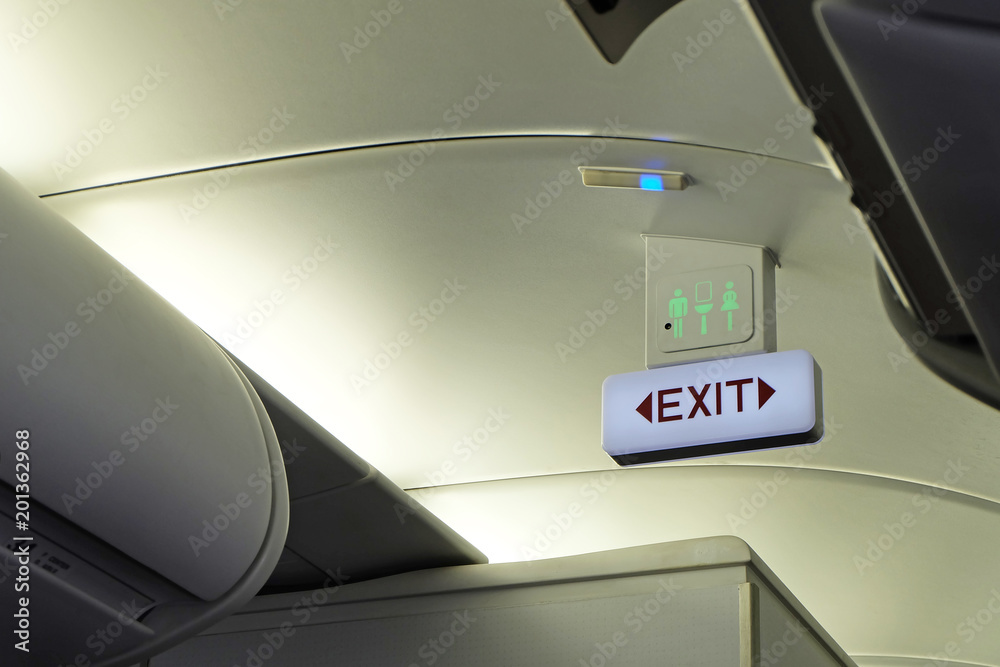 Emergency exit sign and toilet sign on airplane. Stock Photo | Adobe Stock