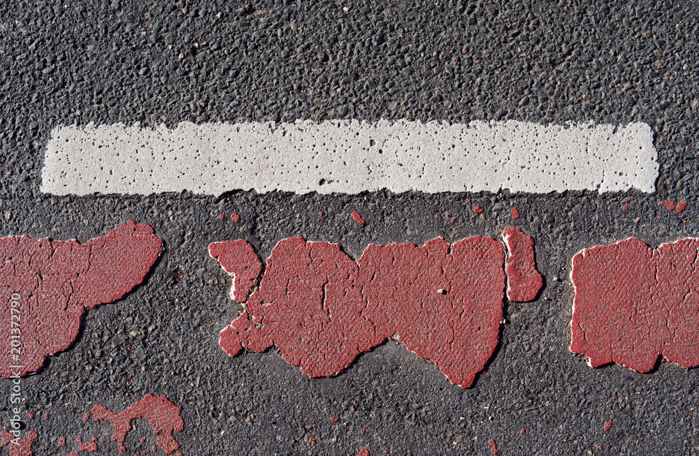 Roads: Worn road marking between cycle path and roadway on a dry inner ...