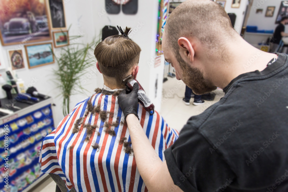 Foto de Men's haircut in barbershop. Master barber does a haircut to ...