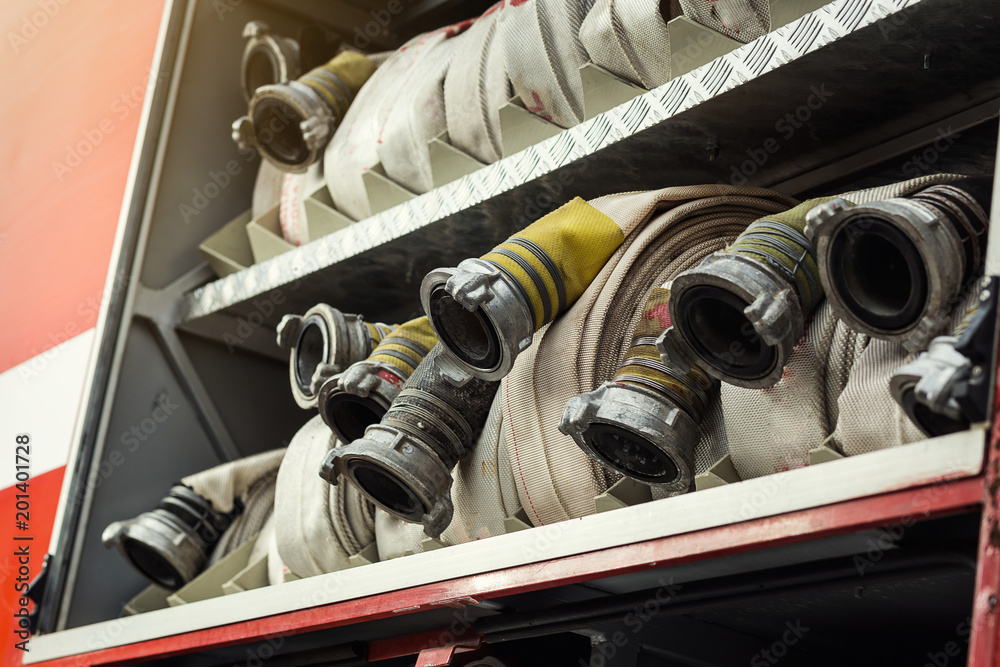 Compartment of rolled up fire hoses on a fireengine. Emergency safety ...