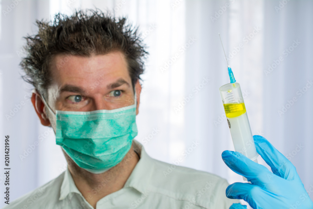 weird looking doctor holds large syringe in his hand, concept of ...