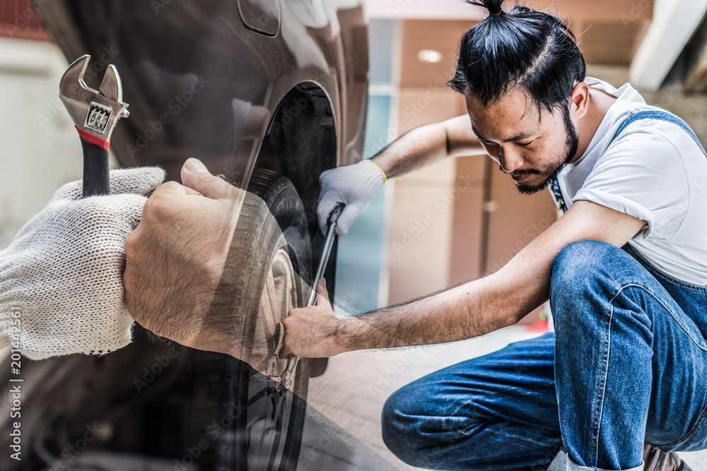 Fixing car engine in automobile repair garage. Handsome mechanics in ...