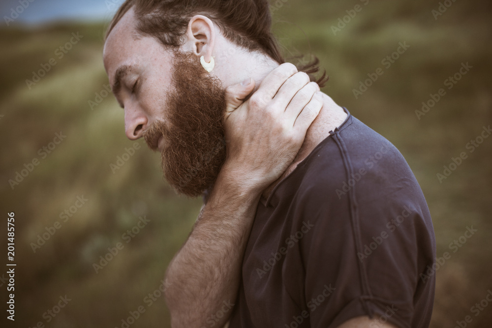 Portrait of a handsome man holding his neck Stock Photo | Adobe Stock