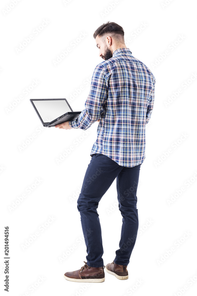 Standing professional business man holding and using laptop computer ...