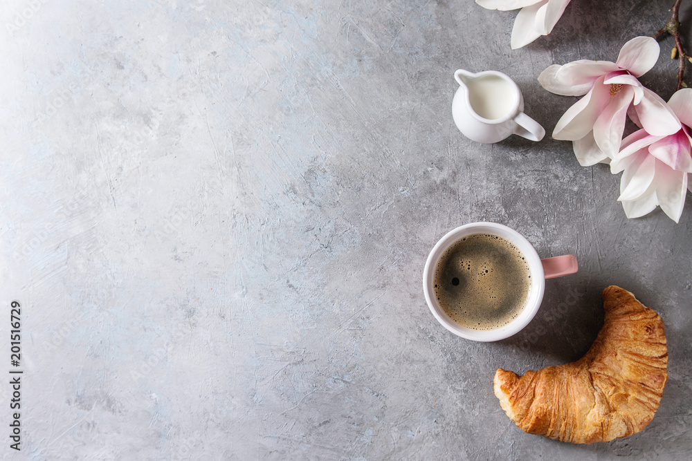 Pink mug of black espresso coffee, french bake croissant, cream and ...