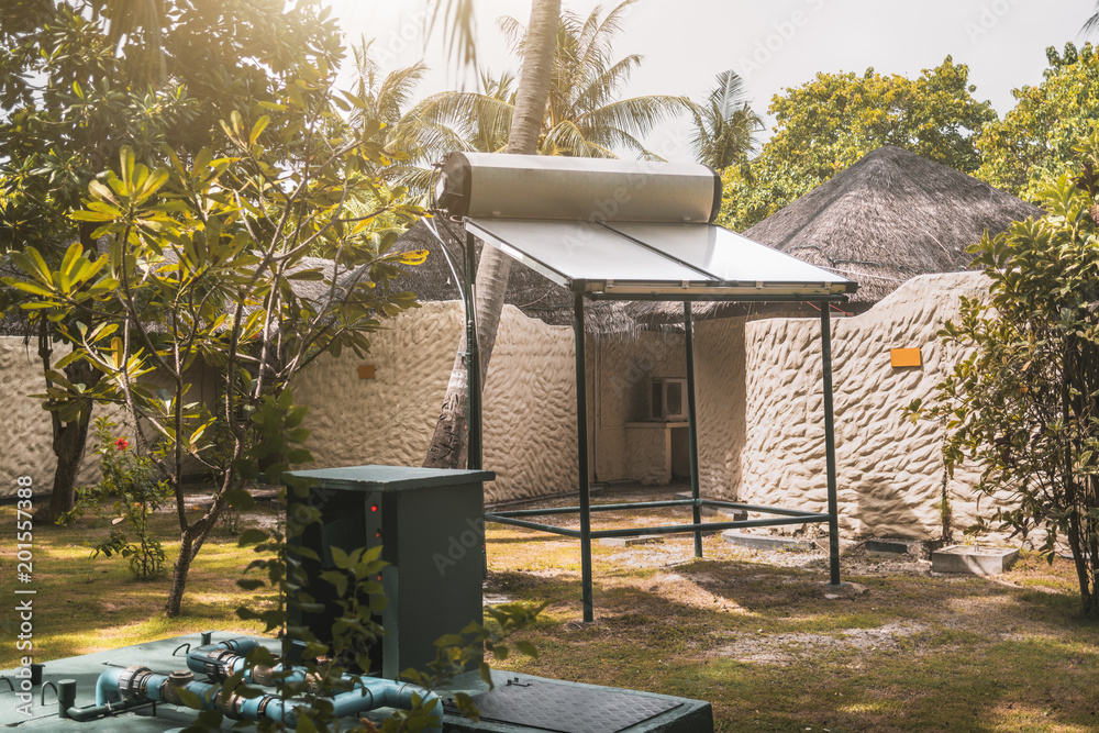 Modern solar water heater next to shack in a tropical resort, with the ...
