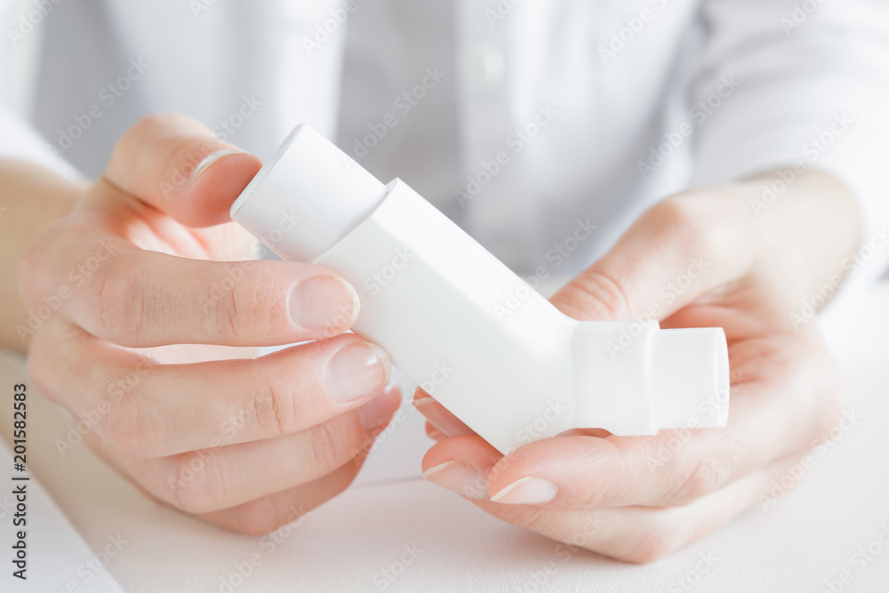 Doctor's hands giving white inhaler of asthma for treatment of patient ...
