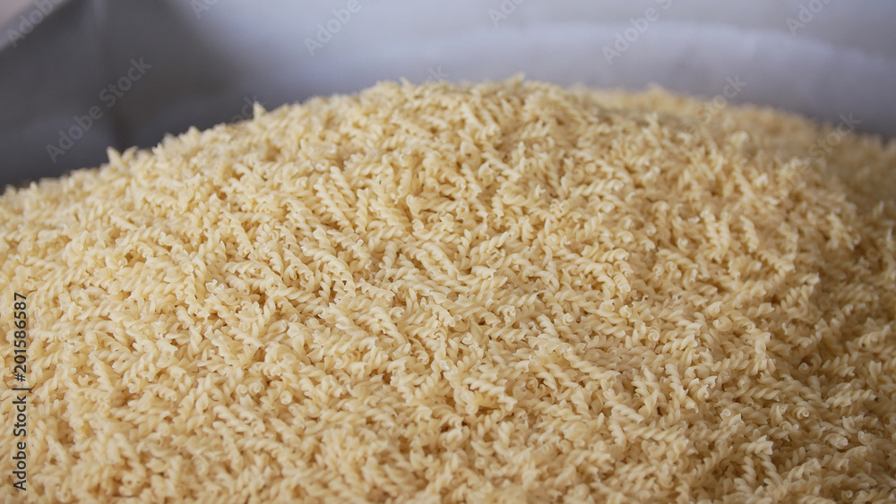Raw macaroni from a conveyor belt at the pasta manufactury Stock Photo ...