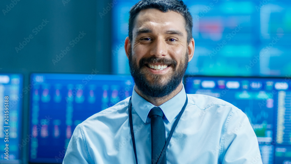 Handsome Stock Market Trader Smiles into the Camera. Behind Him ...