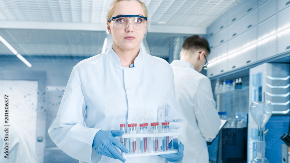 Shot of Young Female Scientist Walking with Case of Test Tubes Through ...