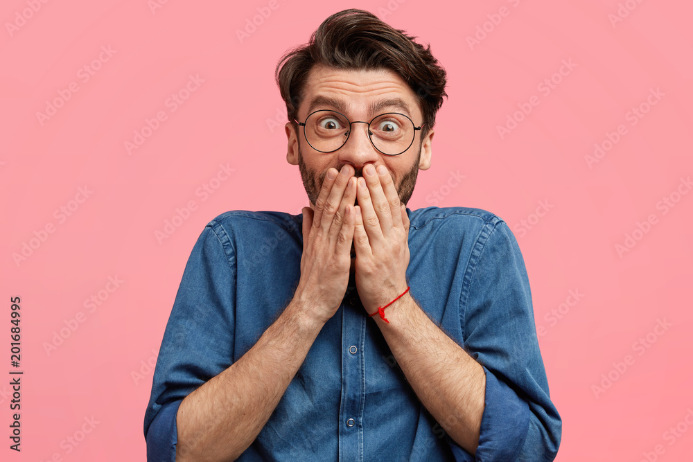 Image of attractive fashionable guy in denim shirt, giggles joyfully ...