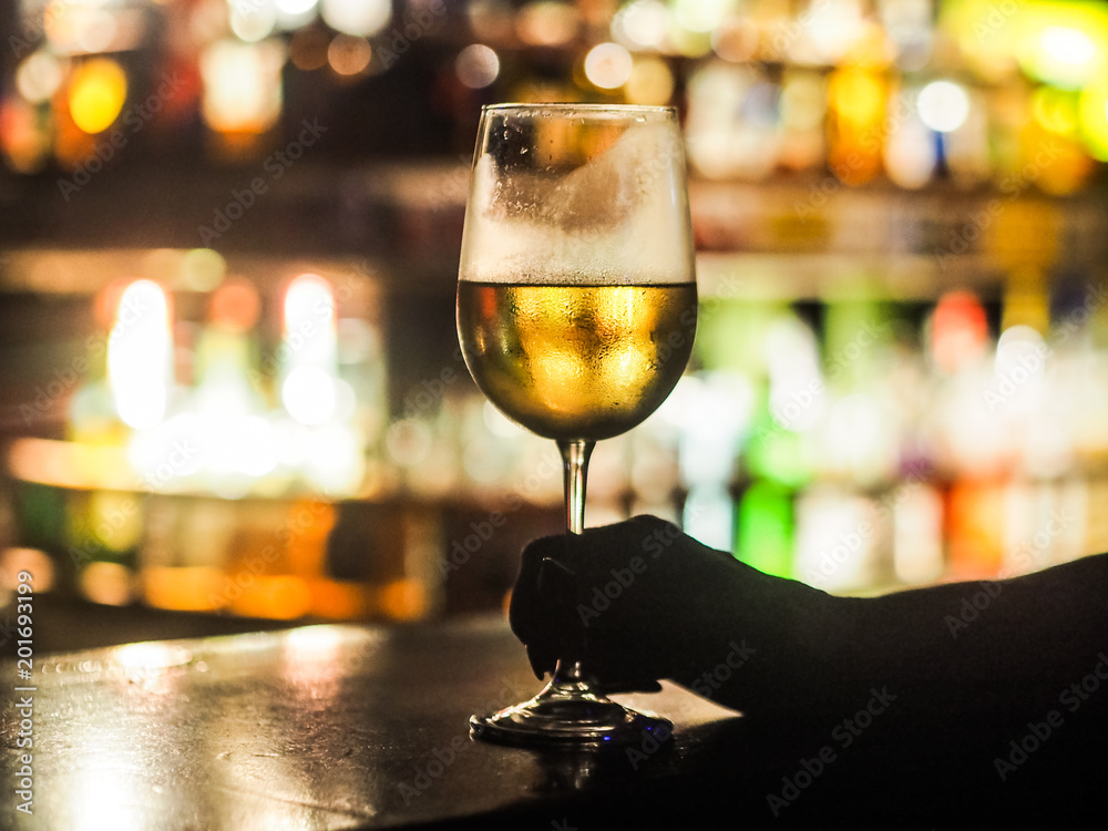 closeup of a single white wine glass standing alone on the bar counter ...