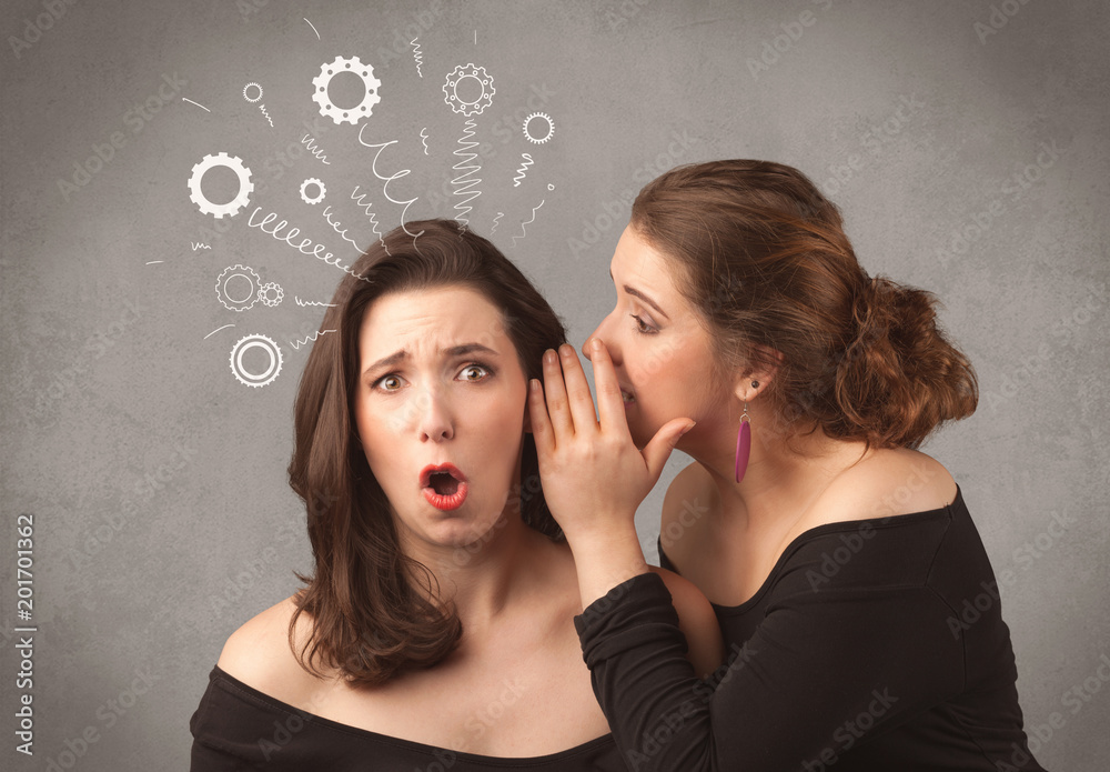 Two girlfriends in elegant black dress sharing secrets with each other ...