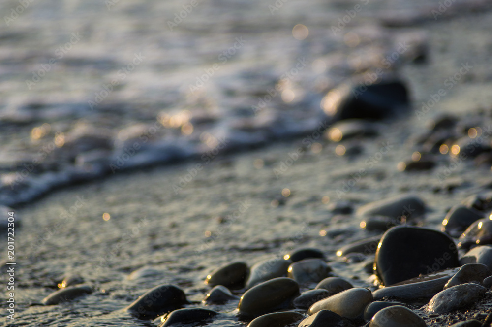 pebble stones on the sea beach, the rolling waves of the sea with foam ...