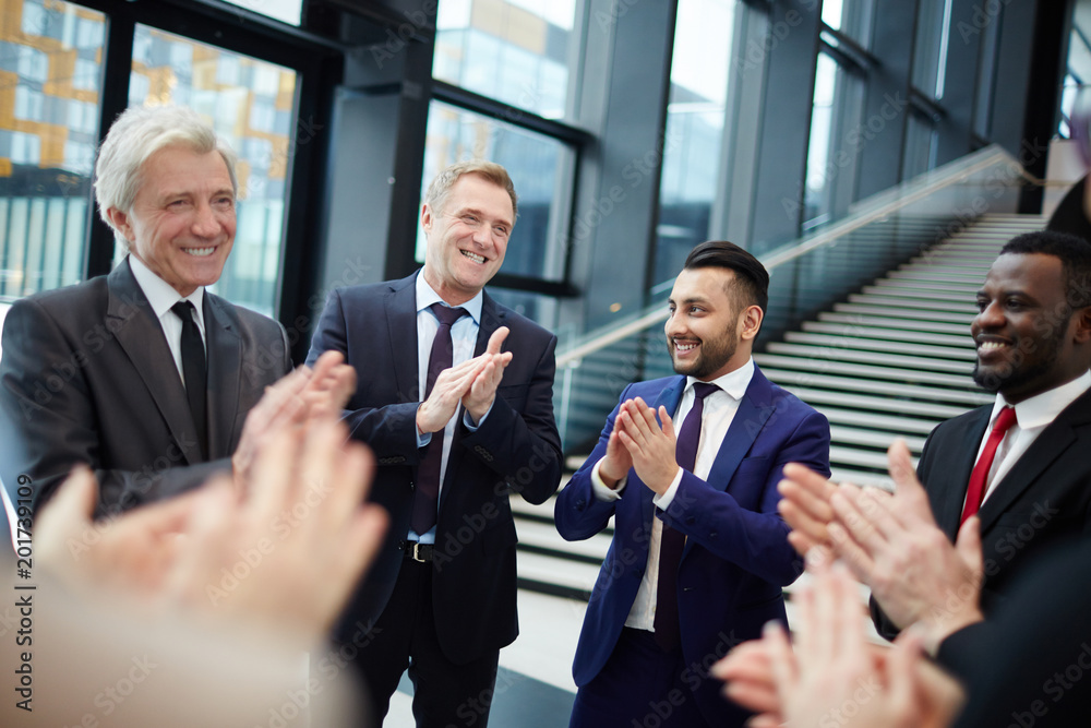 Team of cheerful and successful business people clapping their hands ...