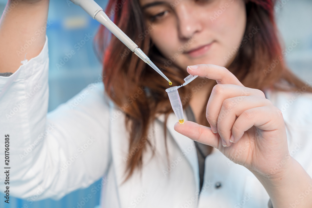 Woman technician with multipipette in genetic laboratory PCR research ...