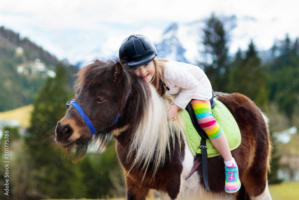 Kids riding pony. Child on horse in Alps mountains Stock Photo | Adobe ...