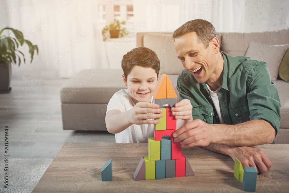 Happy family is playing together at home. They are making construction ...