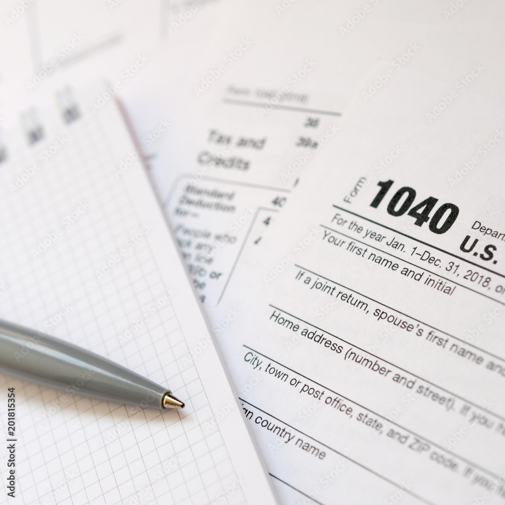 The pen and notebook is lies on the tax form 1040 U.S. Individual ...