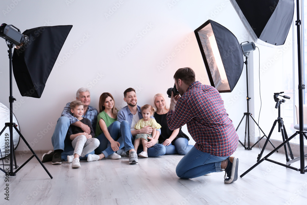 Professional photographer taking photo of family in studio Stock Photo ...