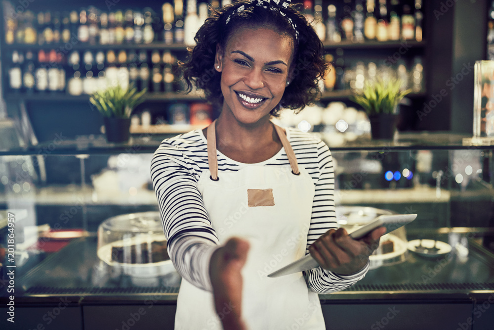 Smiling African hostess offering a handshake in her trendy cafe Stock ...