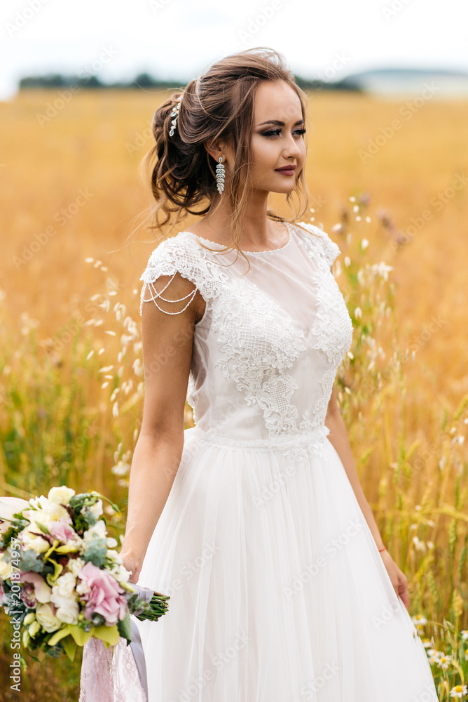 Beautiful bride with wedding bouquets in her hands is standing in the ...