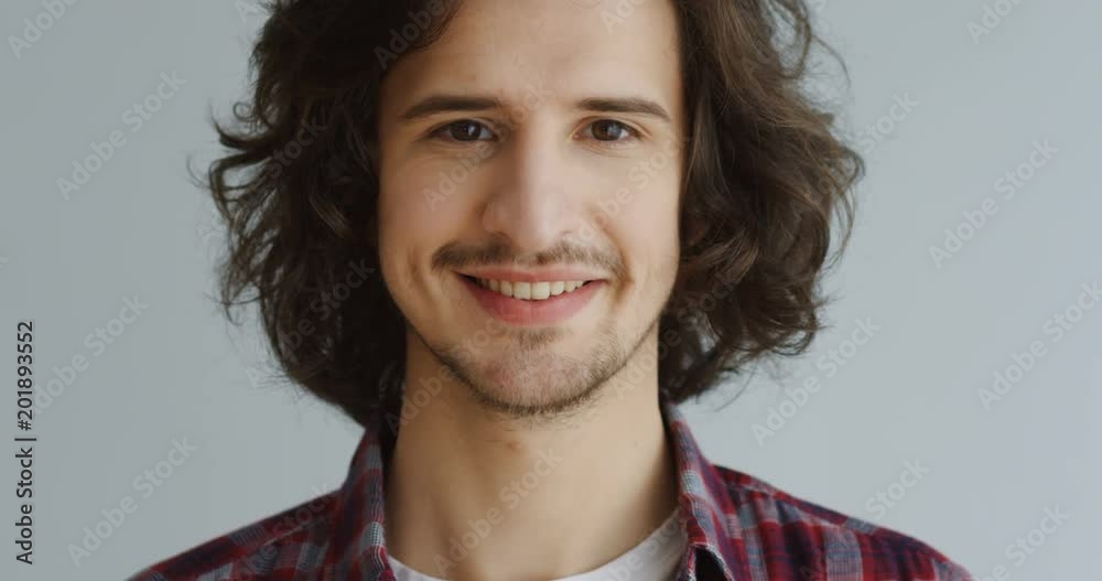 Portrait of the male face with long hair looking straight in the camera ...