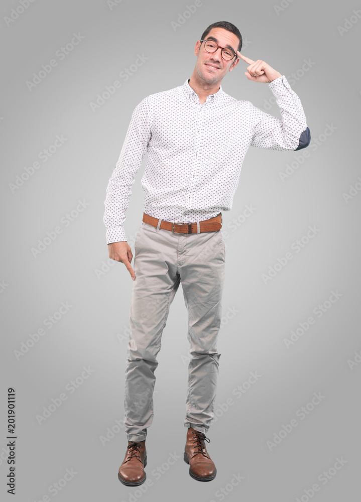 Confident young man with gesture of concentration pointing his head ...