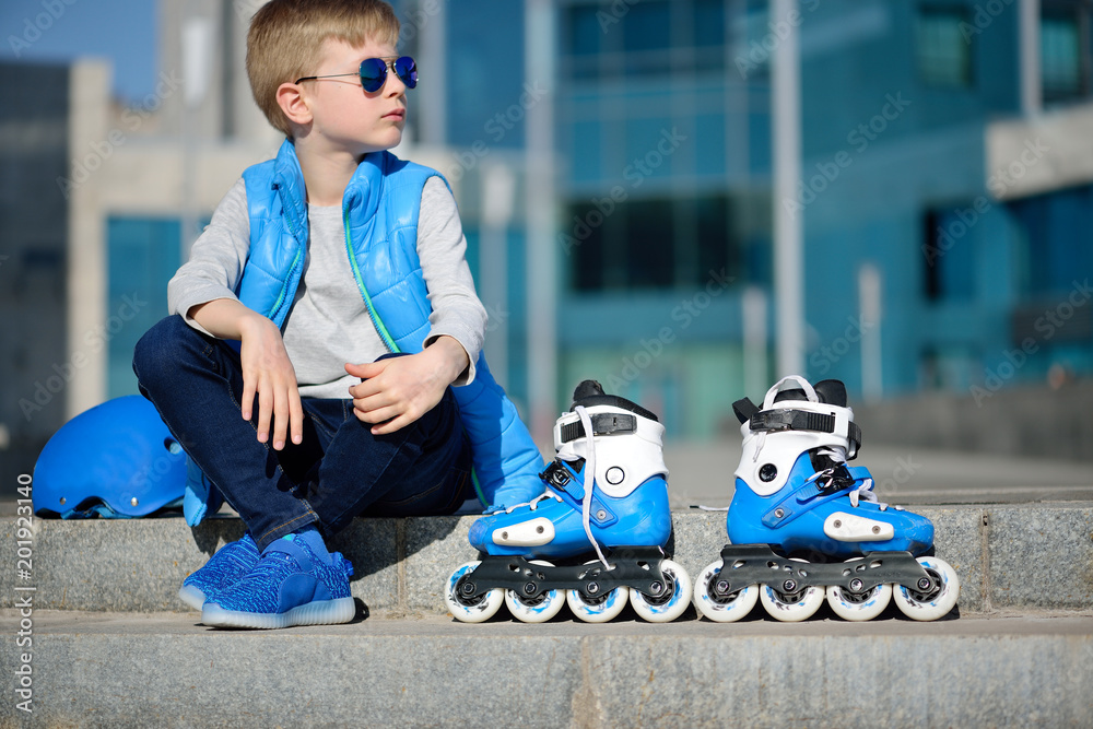 Boy siting with inline roller skates at outdoor skate park Stock Photo ...