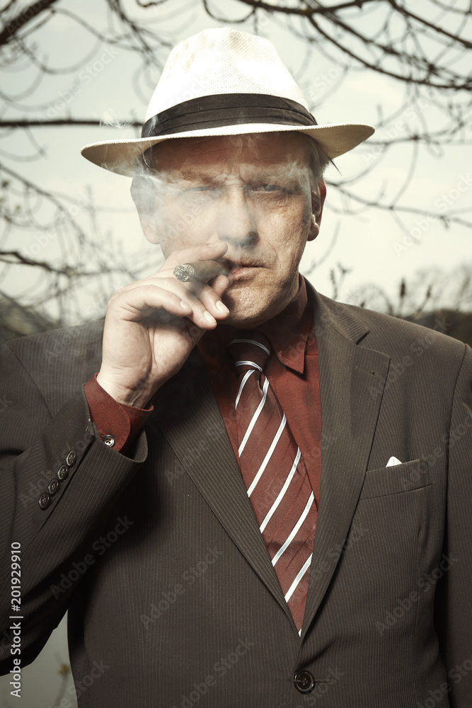 Bad evil man in mob style smoking cigar outdoor Stock Photo | Adobe Stock