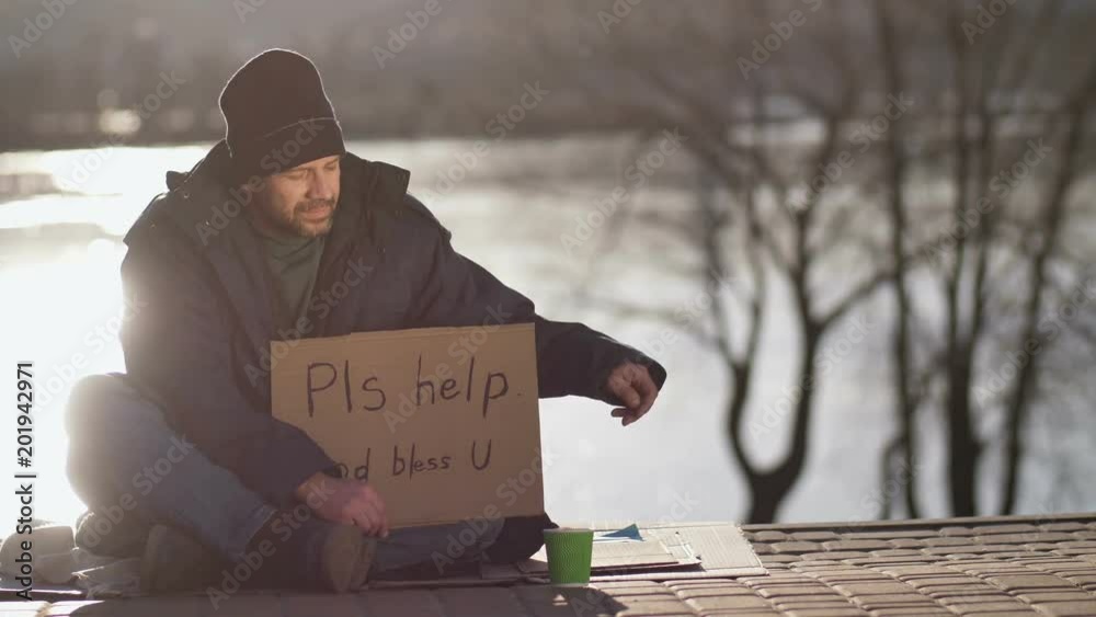 Video Stock Woman passing by homeless begging man sitting on pavement ...