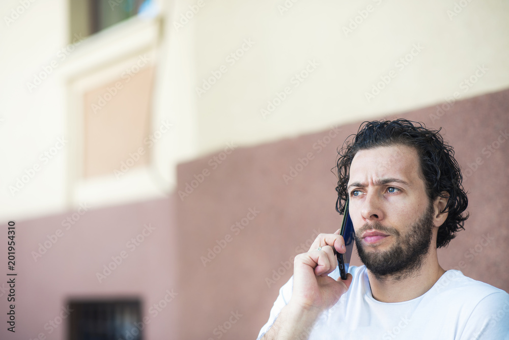 Worrying phone call, young bearded man expressing worry while talking ...