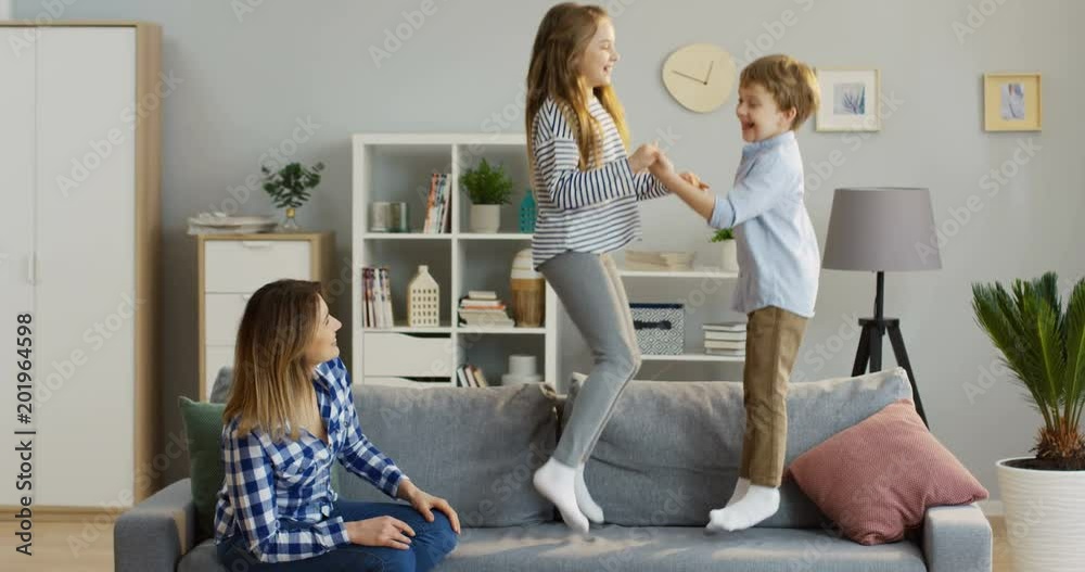 Small cute children, brother and sister, having fun in the living room ...
