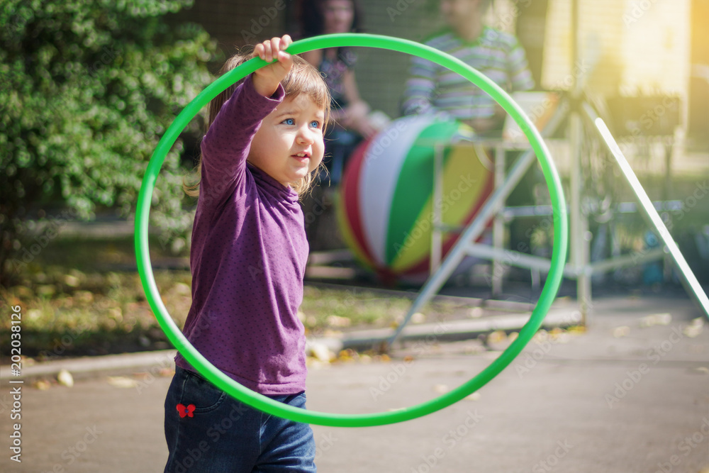 little girl child playing with a hoop outdoors on a summer day Stock ...