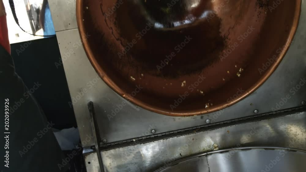 Popped corn being emptied from a copper kettle at a fair food booth ...