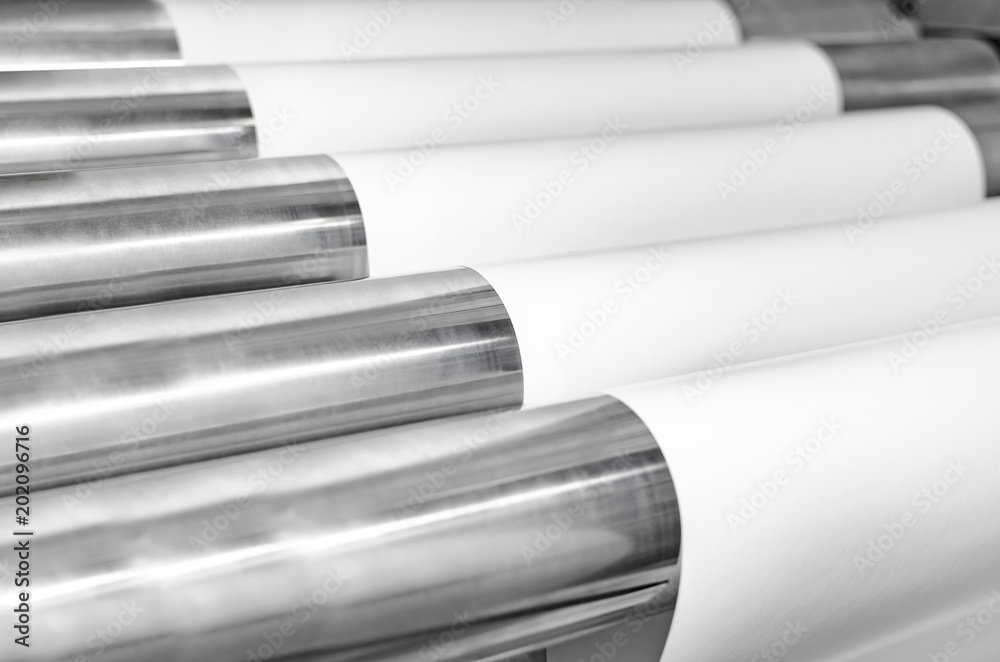 Offset printing press at work with layers of roll paper running on ...