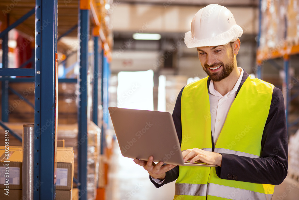 Warehouse worker. Positive smart man wearing uniform while working as a ...