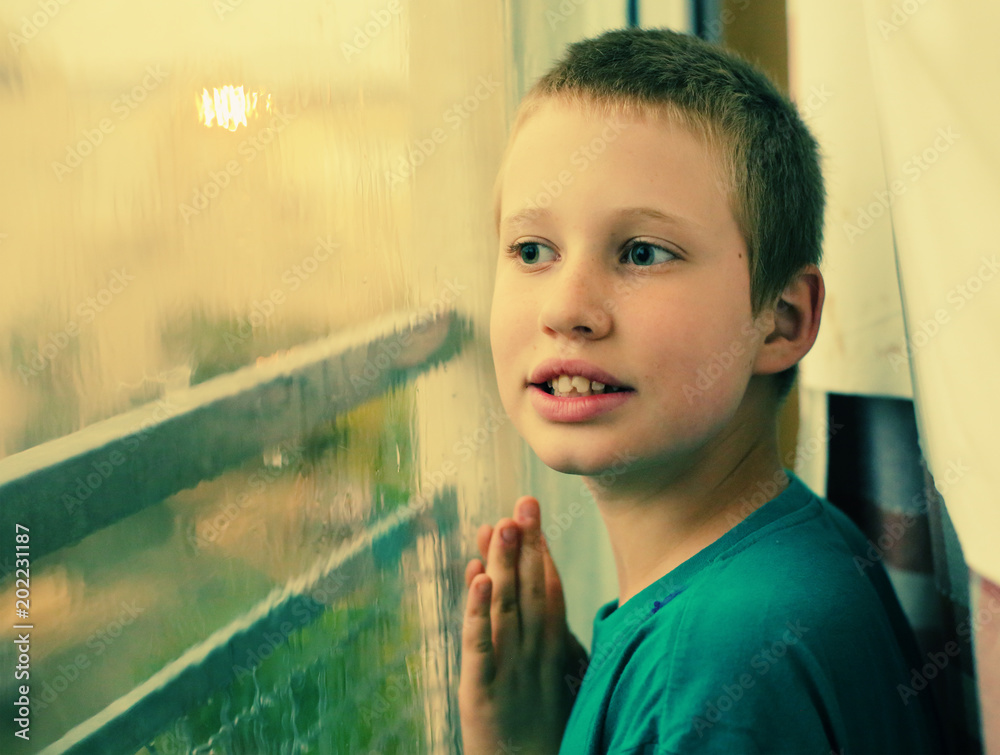 Cute 10 year old autistic boy looking at the rain Stock Photo | Adobe Stock