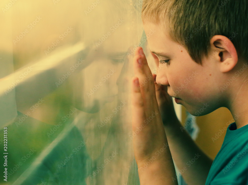 Cute 10 year old autistic boy looking at the rain Stock Photo | Adobe Stock