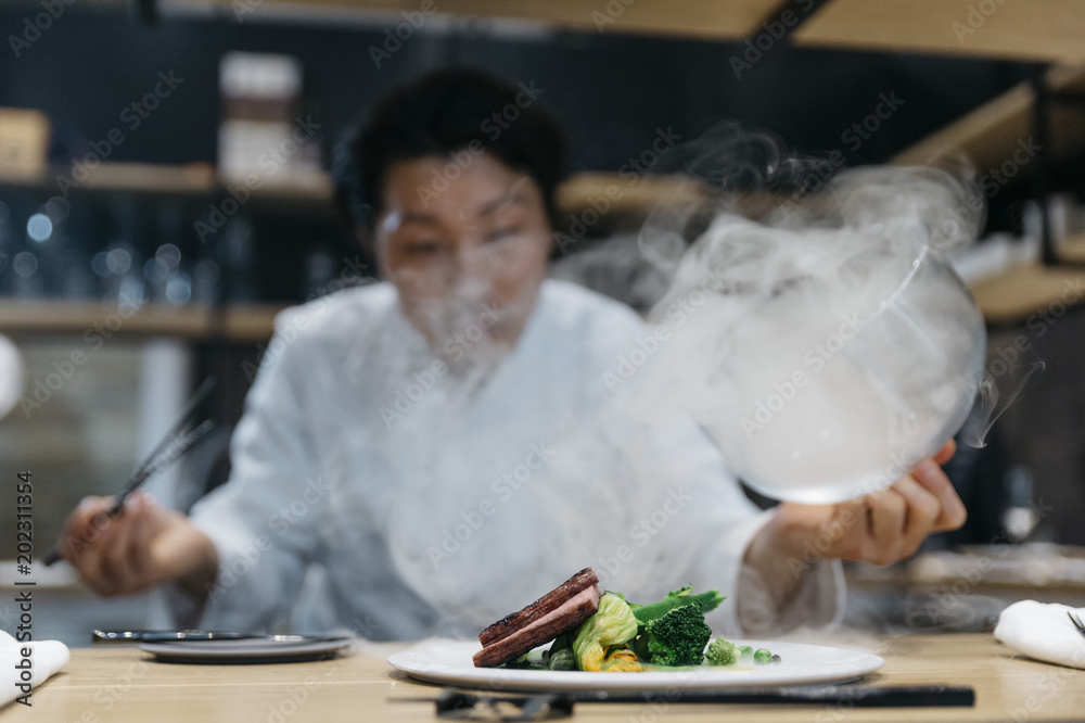 Chef cooking in restaurant with smoke dish Stock Photo | Adobe Stock