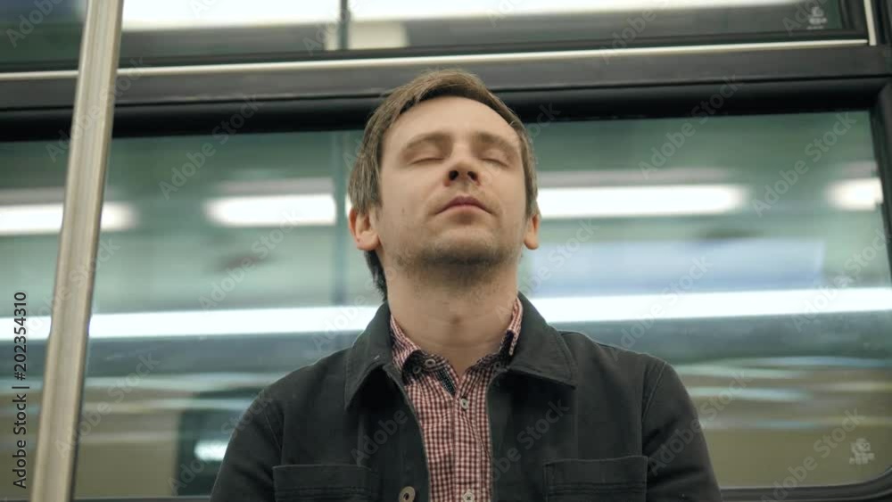 man sleeping in a underground Metro subway train. Tired worker student ...