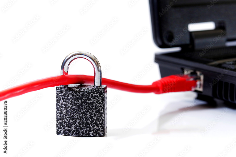 padlock locked on red network cable connected to laptop on white ...