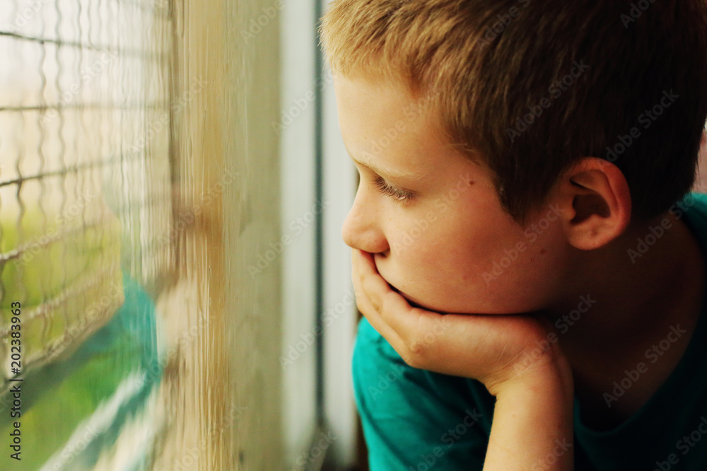 Cute 10 year old autistic boy looking at the rain Stock Photo | Adobe Stock