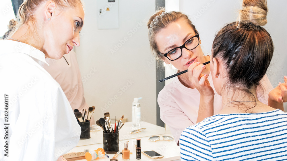 Professional makeup artist teaching students in her makeup studio Stock ...
