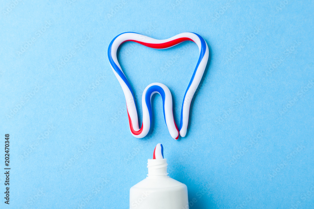 Tooth-paste in the form of tooth. Tube of the paste on blue background ...