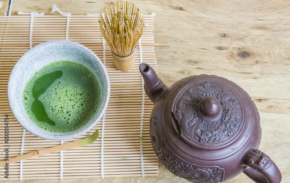 Japanese matcha green tea in stone bowl, brown clay teapot, and bamboo ...